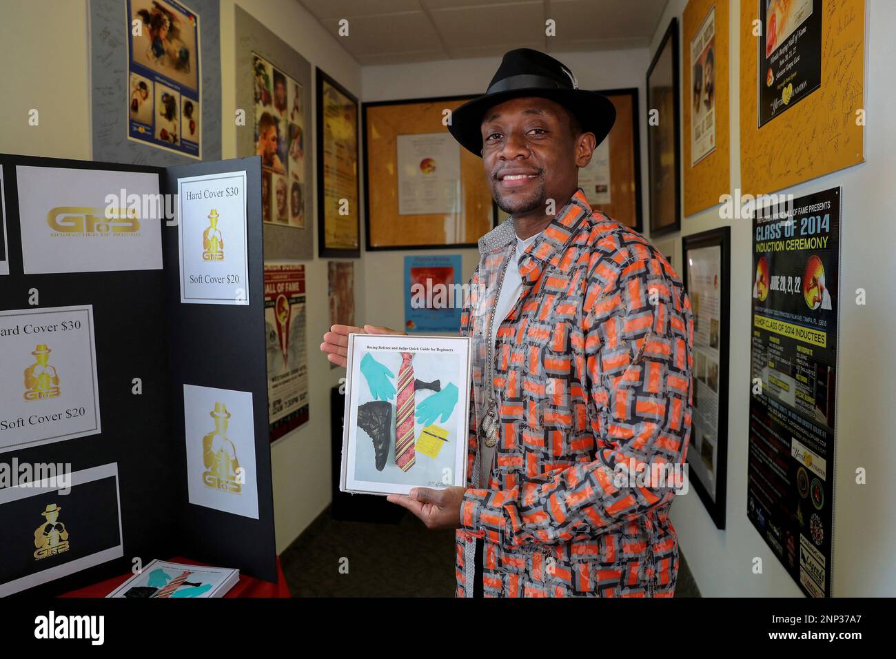 Boxing referee and author Christopher Young poses with his books during ...