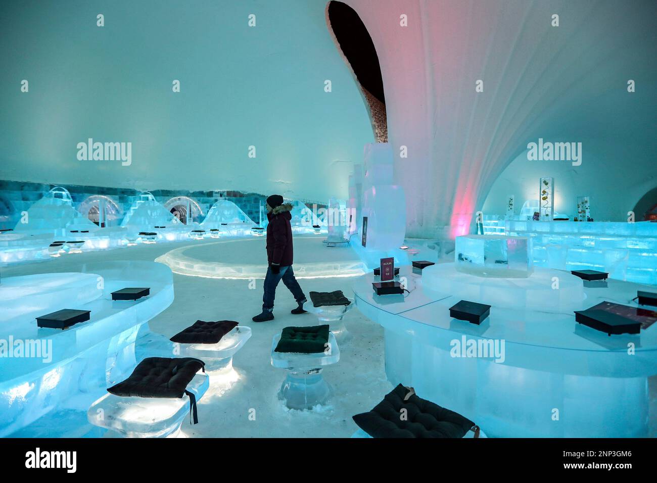 A man walks in an empty ice bar in the annual Harbin Ice and Snow World ...