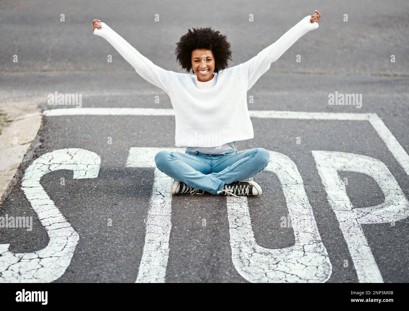 I stop at nothing. Portrait of a happy young woman sitting on a stop ...