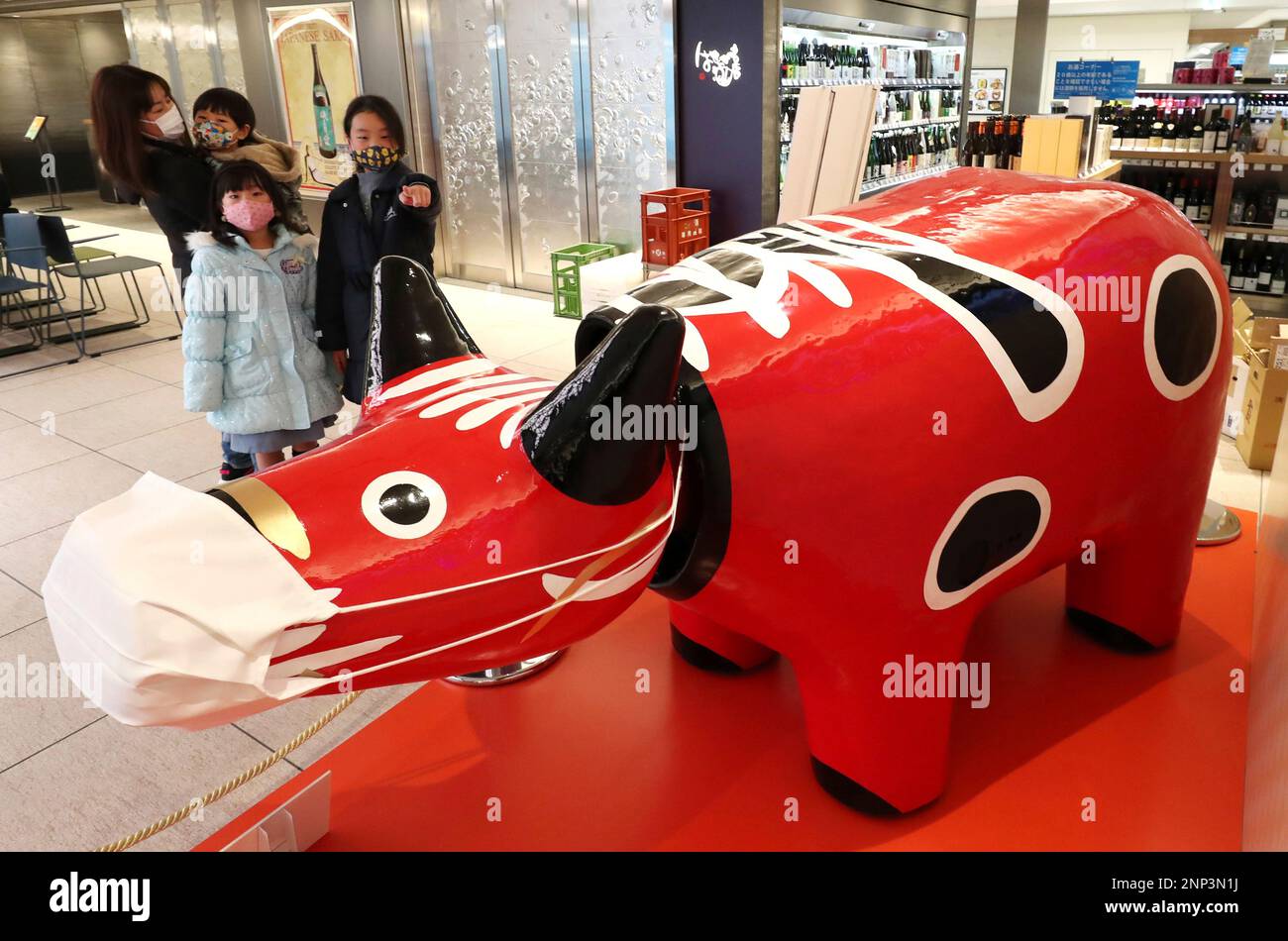 A face-mask worn Akabeko, a toy from Aizu region, Fukushima Prefecture is displayed at Granstan ...