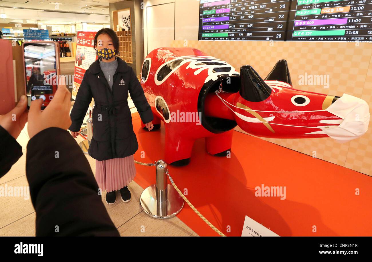 A face-mask worn Akabeko, a toy from Aizu region, Fukushima Prefecture is displayed at Granstan ...