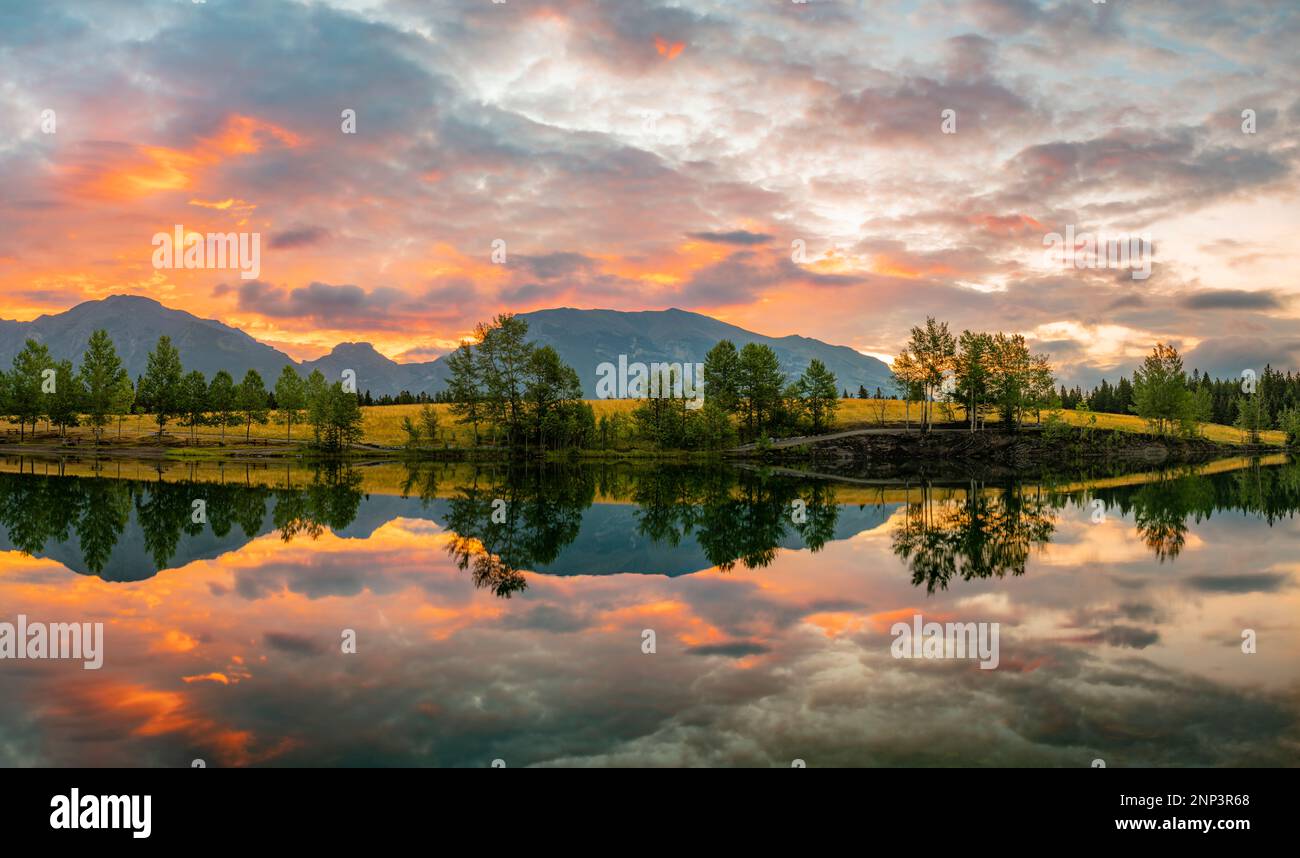 Mountains and trees reflected in lake, Quarry Lake, Canmore, Alberta ...