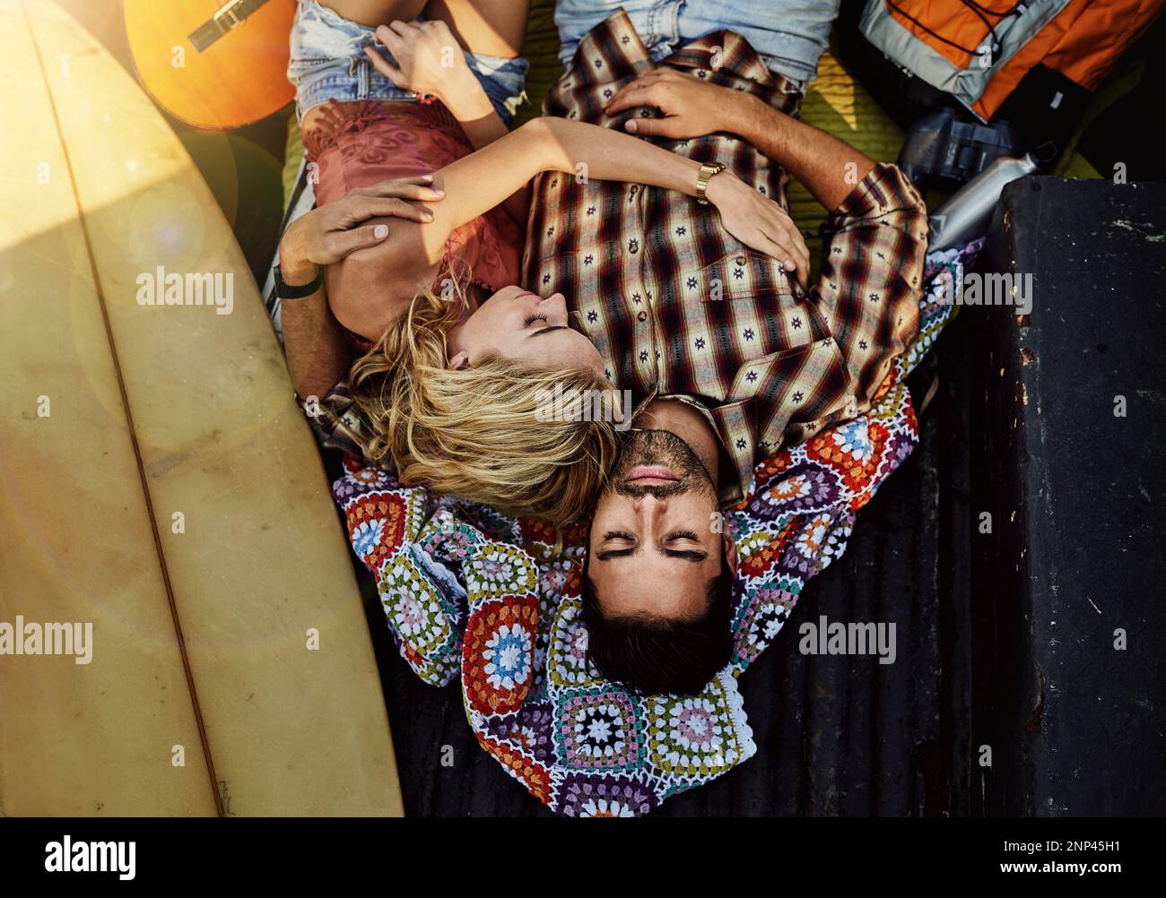 Taking a break after a long drive. a young couple lying at the back of ...