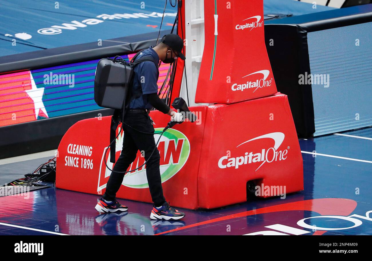 A worker sanitizes a basketball stanchion before the Orlando Magic play ...