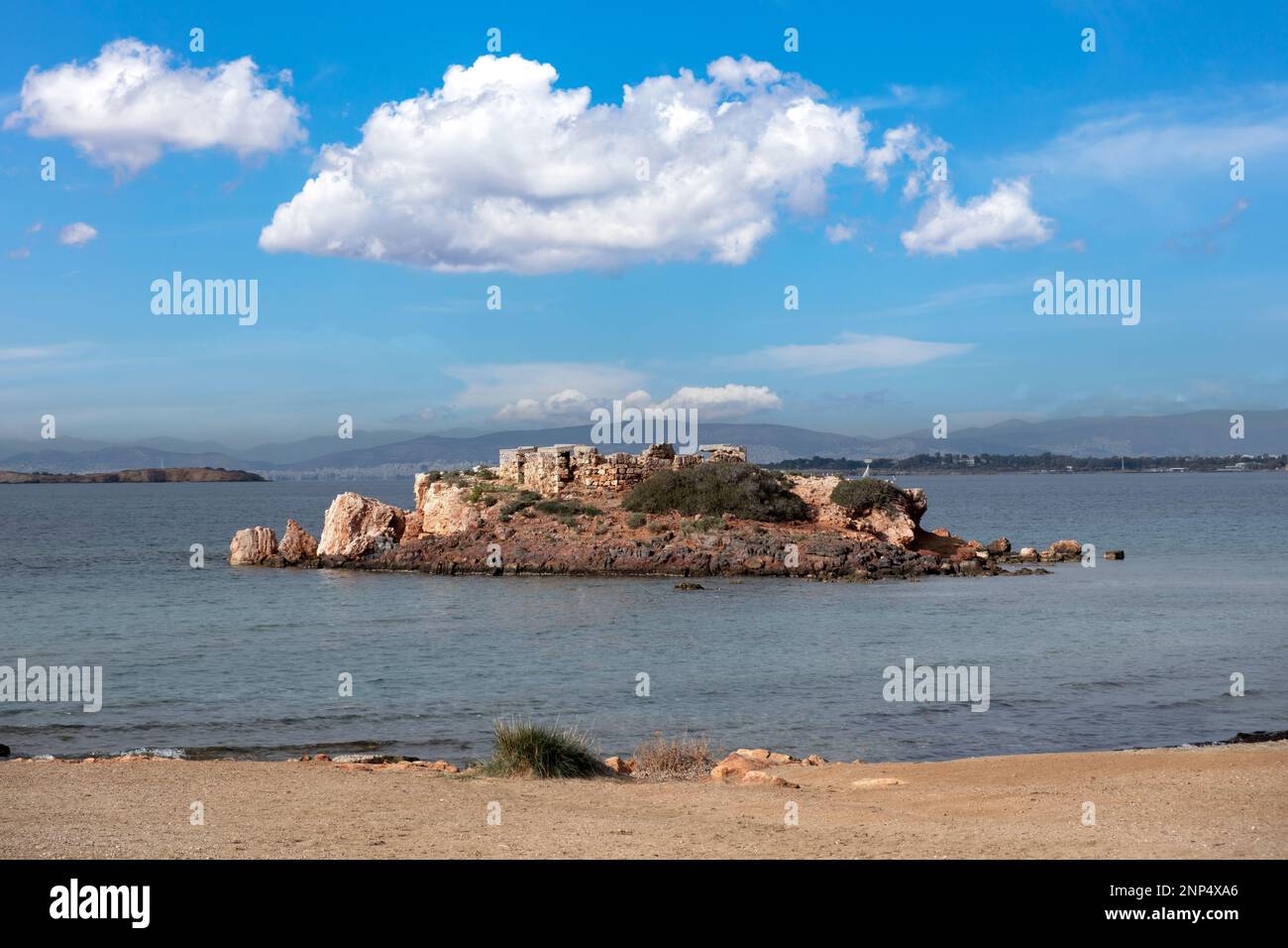 Greece Kavouri Voula. View from beach of small islet with stone ruins ...
