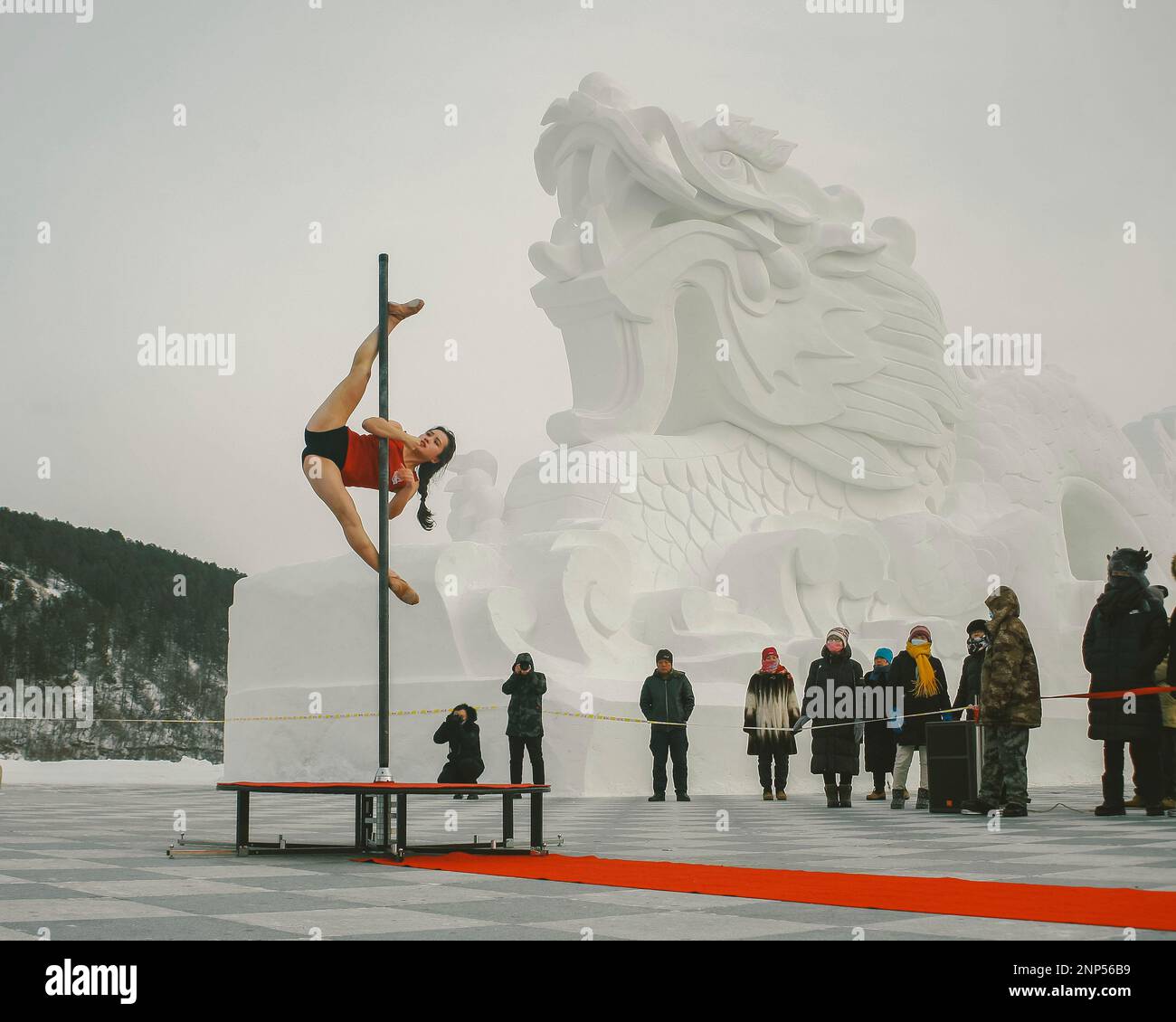 People watch a pole dancer performs in a temperature below 30 degrees ...