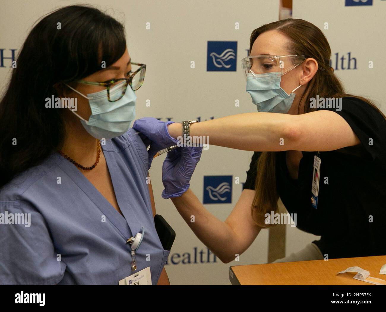 Registered nurse Carol Eickmeyer, left, gets the first vaccination for ...