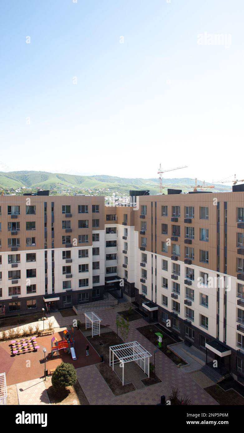 the courtyard of a new multi-storey house with a playground view from ...