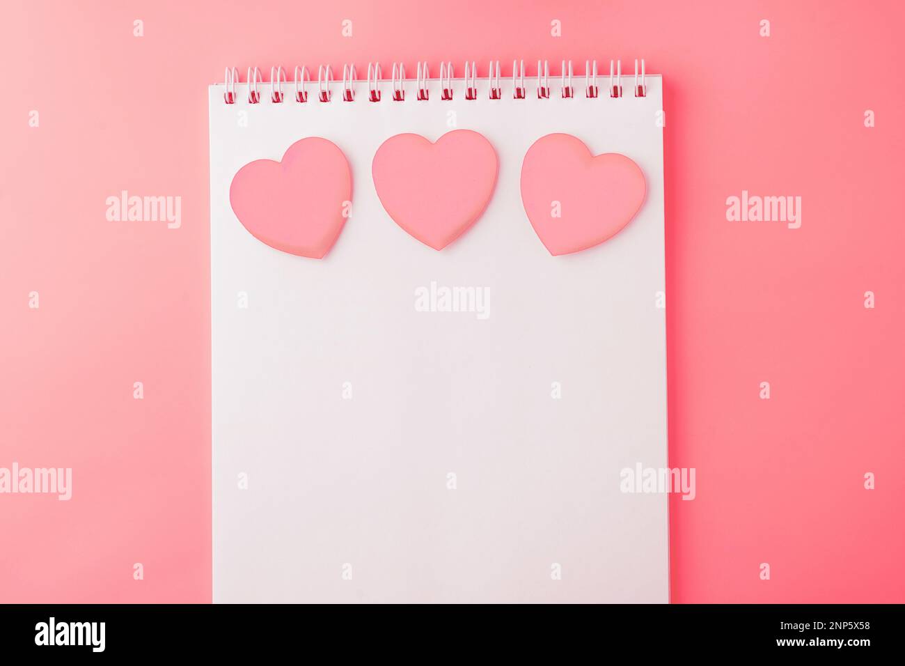 Valentines day background. Open blank notebook and pink hearts on a ...