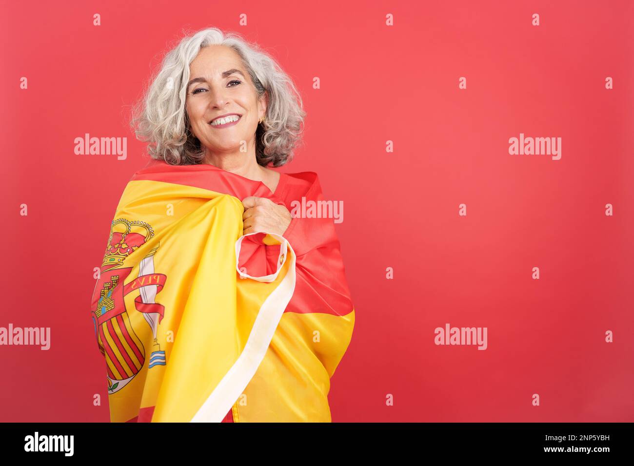 Smiley woman wrapping with a spanish national flag Stock Photo - Alamy
