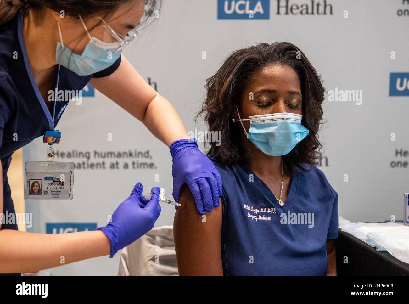 Dr. Medell Briggs-Malonson, right, closes her eyes as she gets an ...