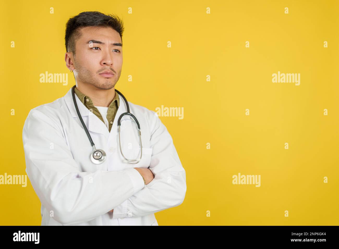 Serious chinese doctor with arms crossed looking away Stock Photo - Alamy