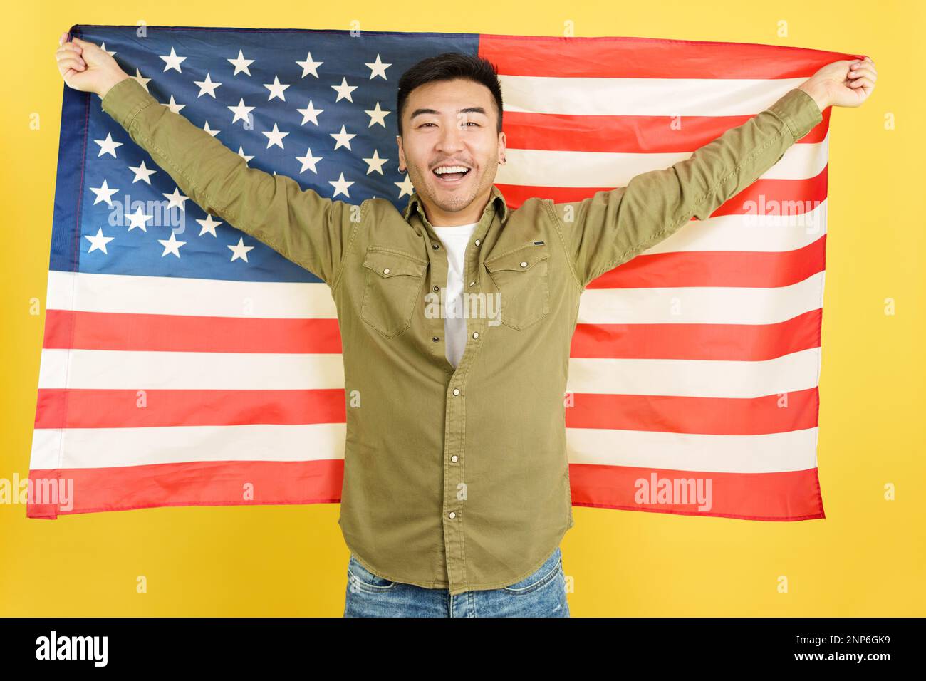 Happy chinese man raising a USA national flag Stock Photo - Alamy