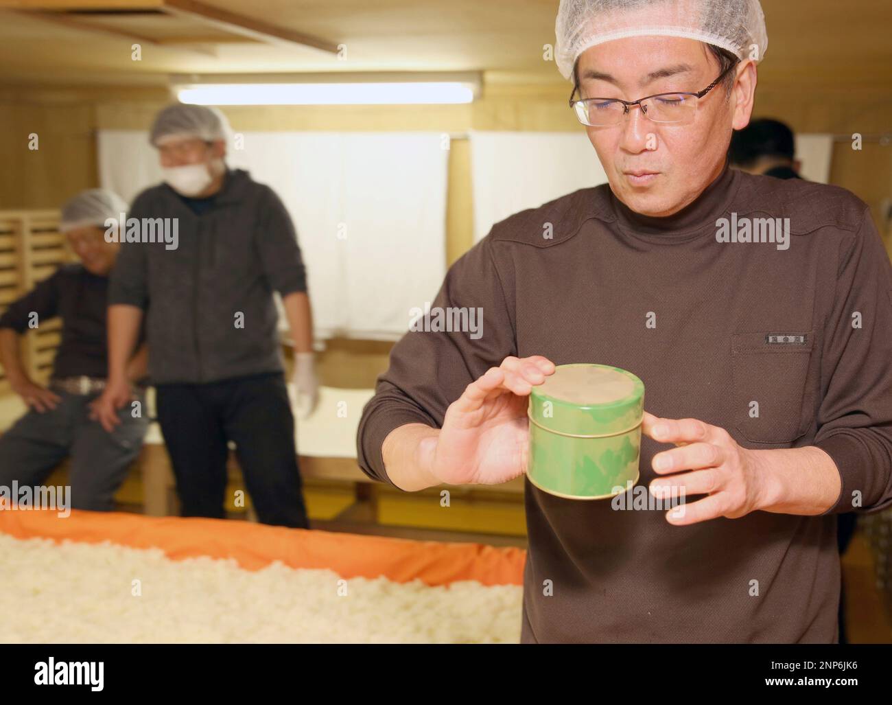 Staffs make sake (Japanese rice wine) by mixing steamed rice with ...