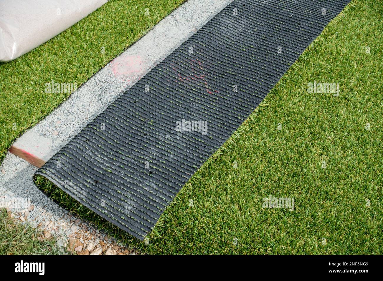 Closeup of folded back artificial grass matting showing green all ...