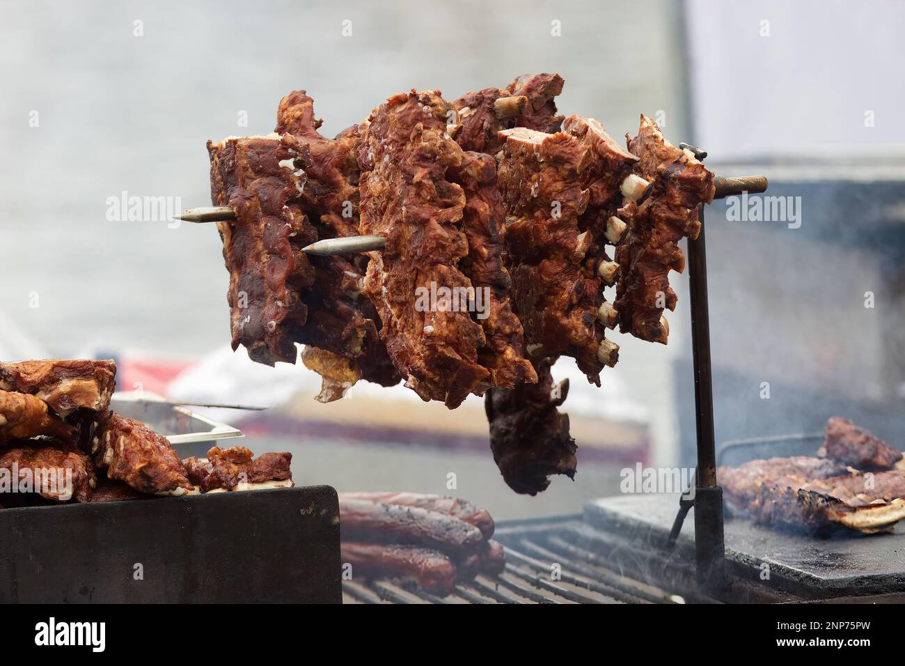 Local butchers stand with ribs and other meats ready for grilling at ...