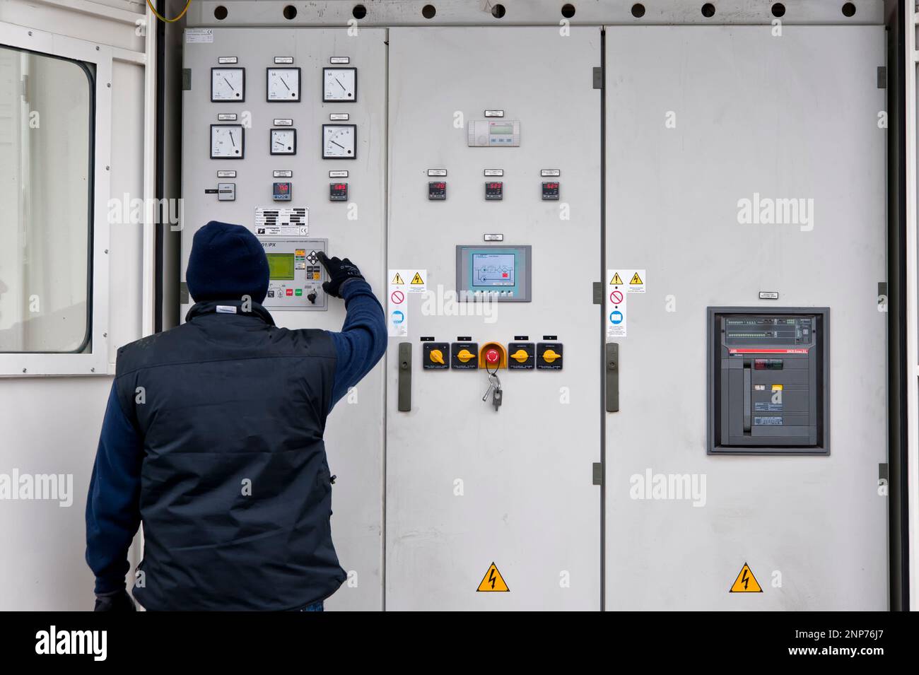 Close-up of technician at work in front of electrical panel. Industrial ...