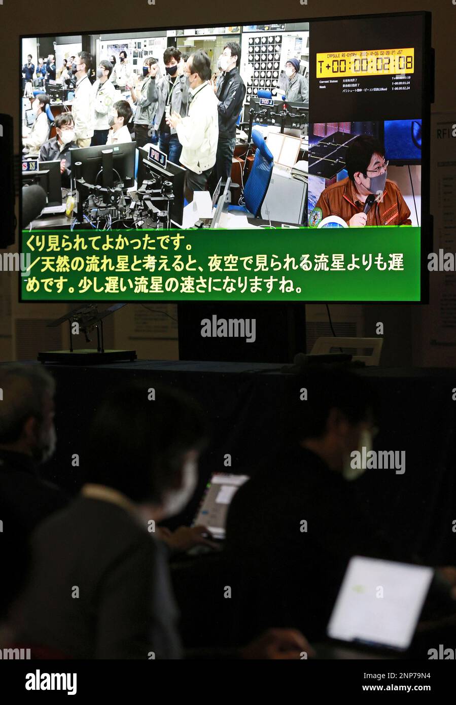 A monitor shows officials at mission control center of Japan Aerospace ...