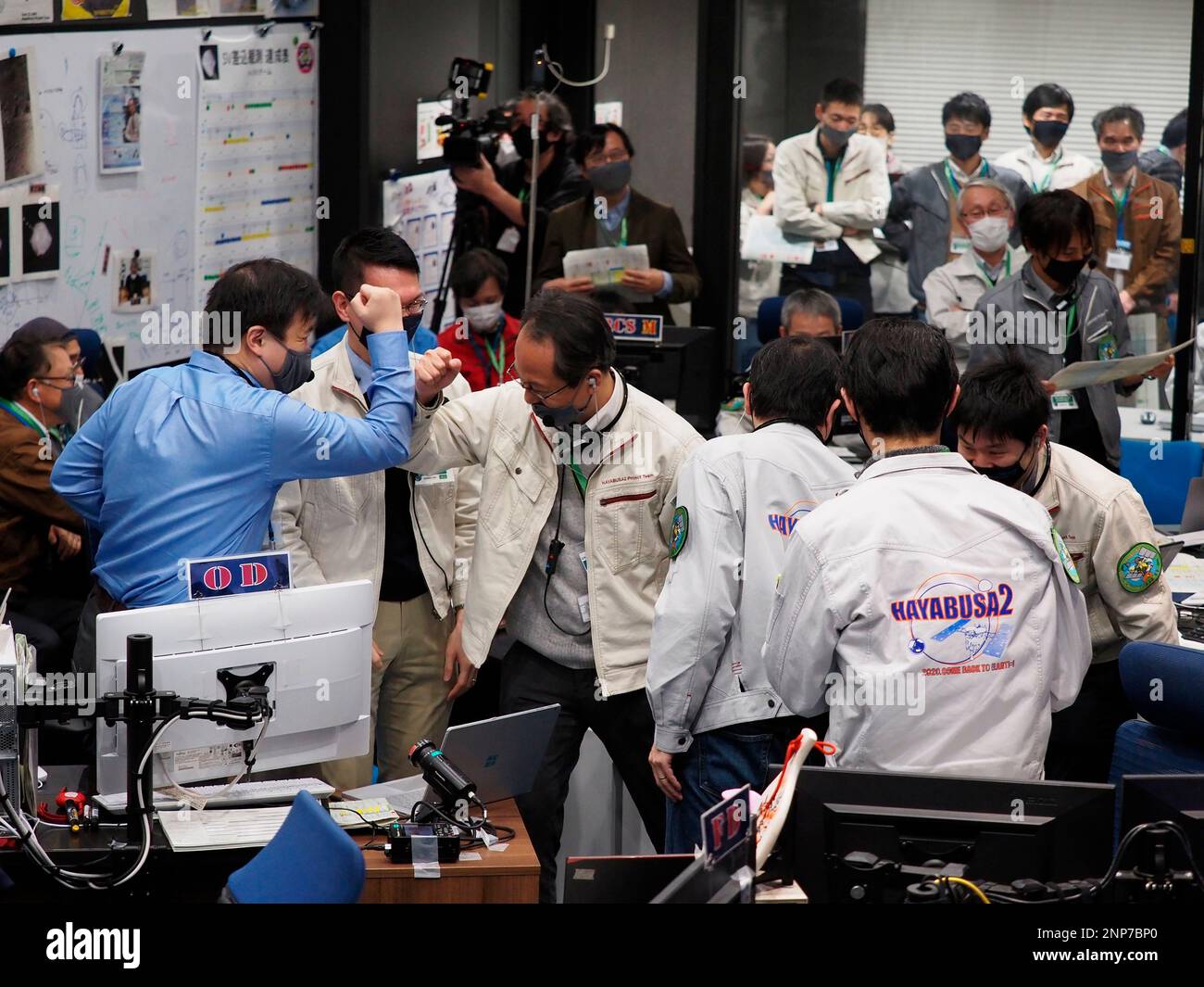 Project members celebrate as the success of trajectory control maneuver ...
