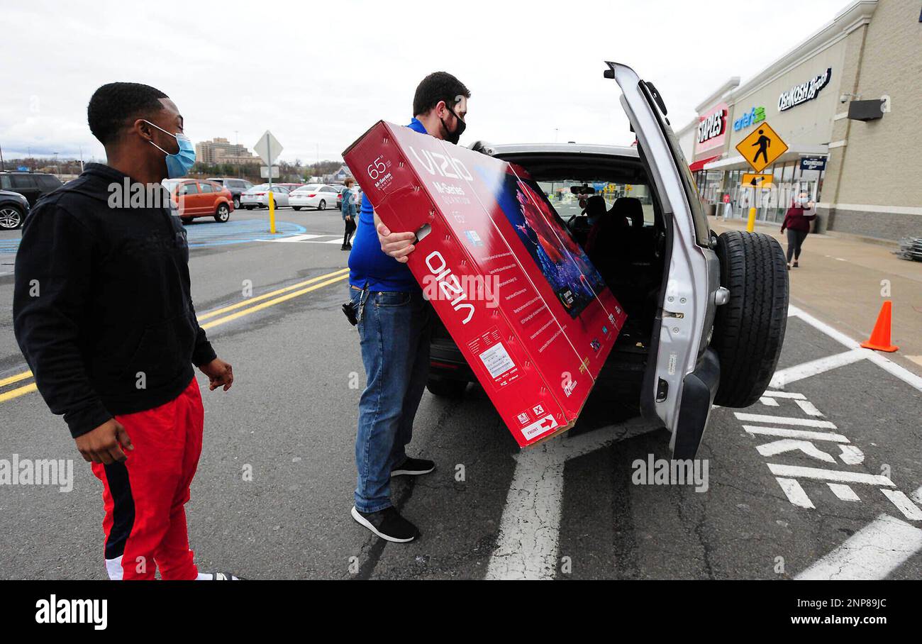 Best Buy employee Jeff Baka loads a 65 inch television into a vehicle ...