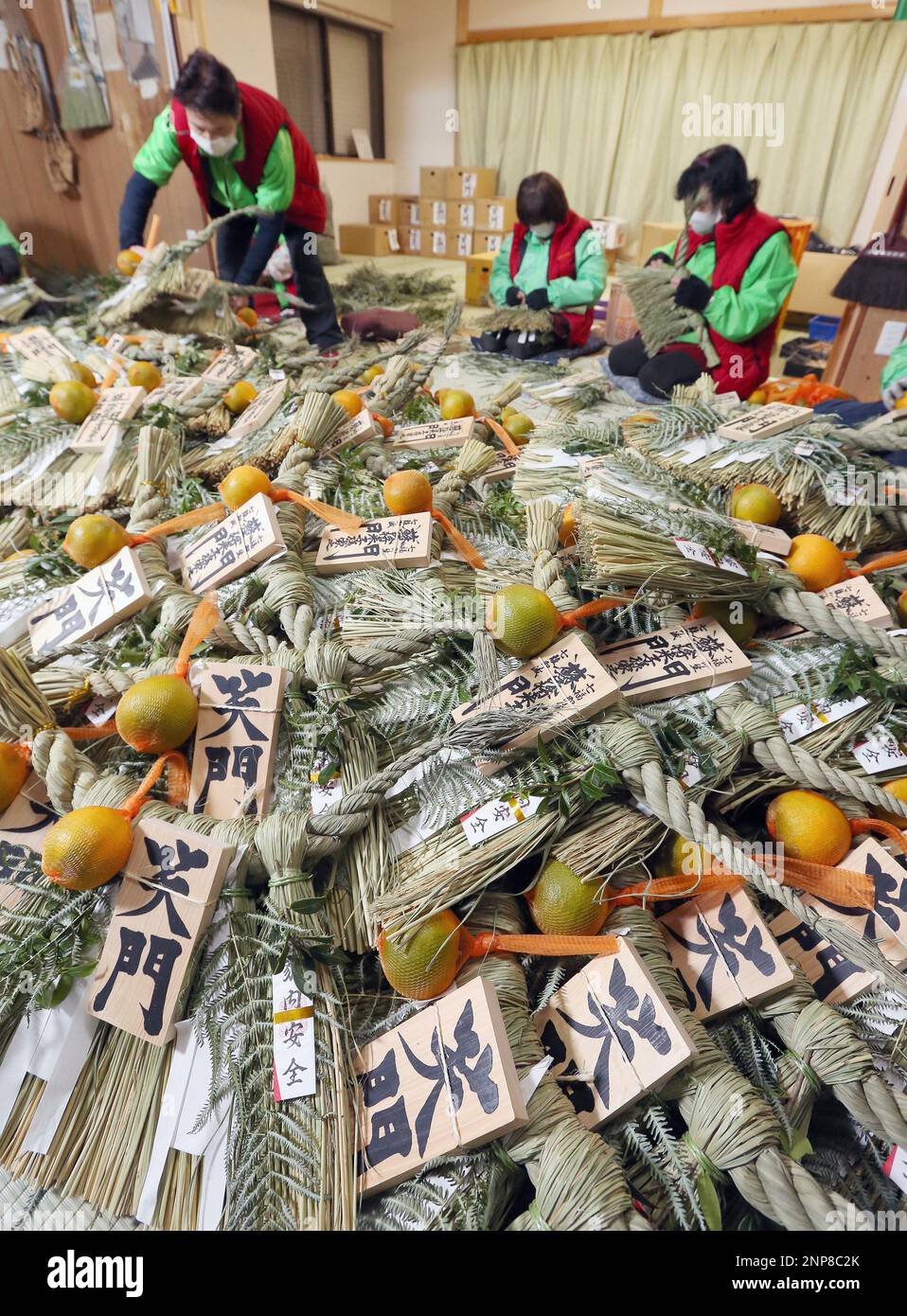Workers of Kadoya Sangyo, are making a shimenawa, sacred rice-straw ...