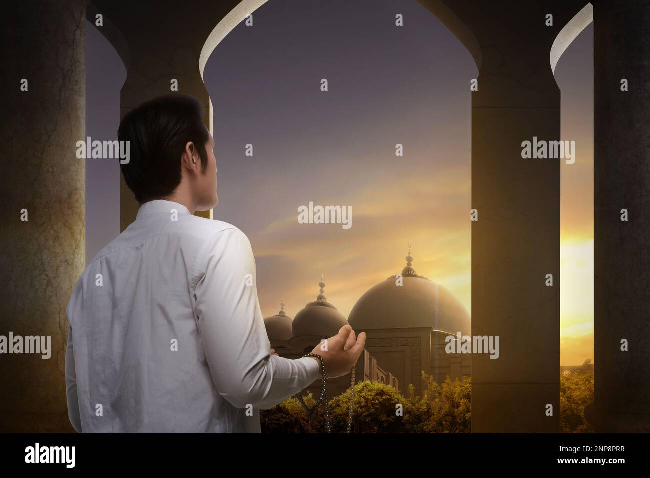 Muslim man standing while raised hands holding prayer beads and praying ...