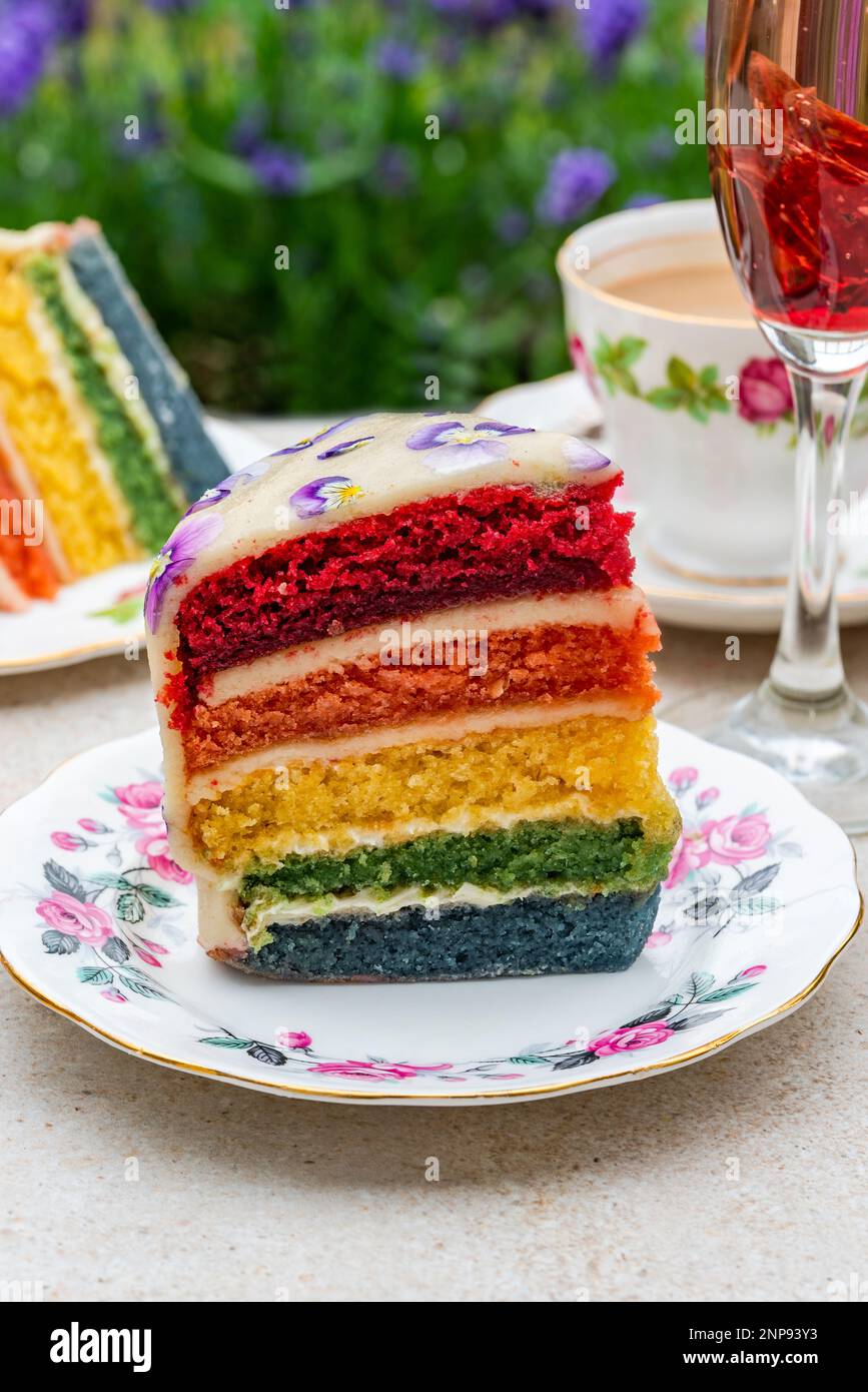Multi layered rainbow cake set on garden table - outdoor dining Stock ...