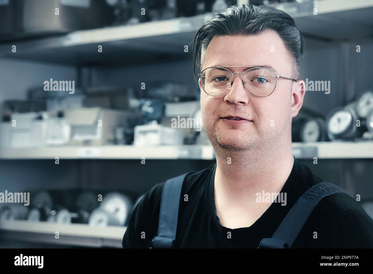 Portrait of white Caucasian man with glasses in production workshop ...