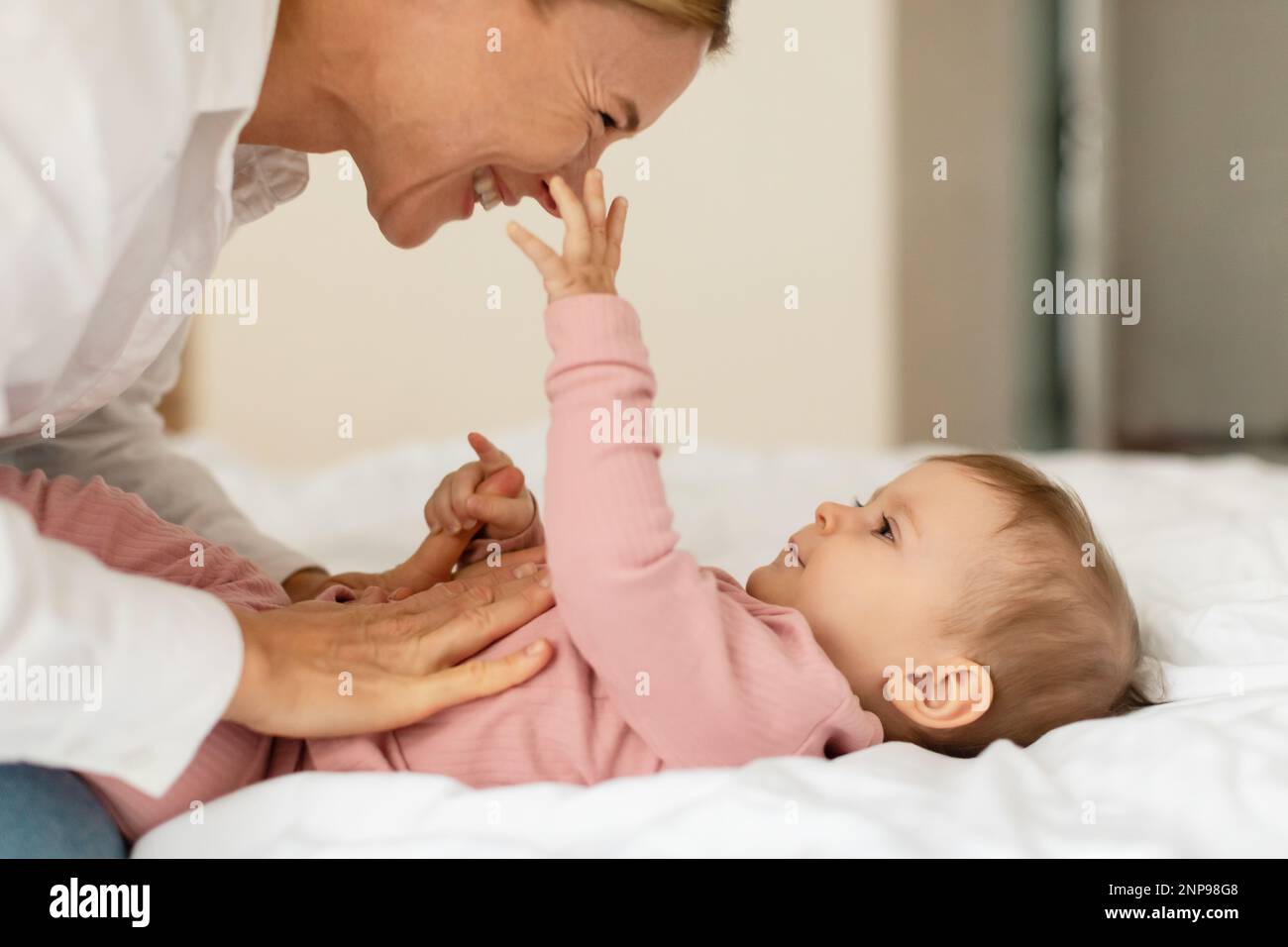 Loving mom playing with baby at home, enjoying motherhood and maternity ...