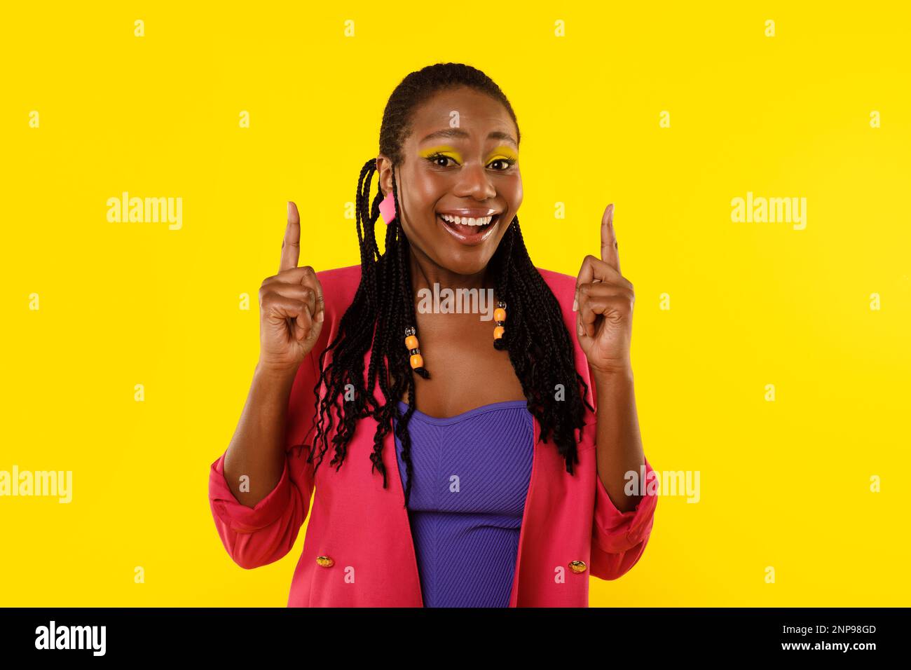 Black Woman With Bright Makeup Pointing Fingers Upward, Yellow ...