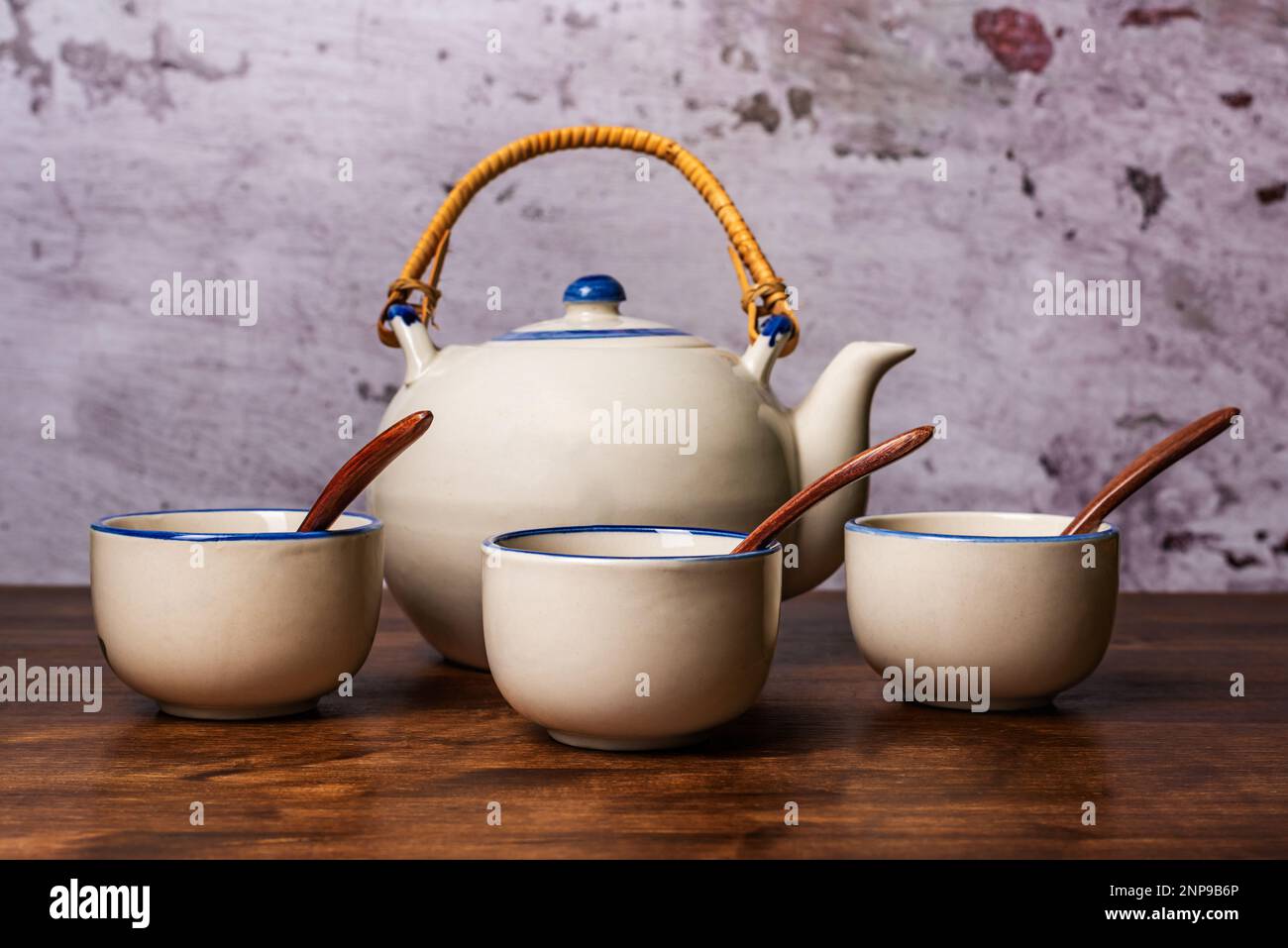 Porcelain teapot next to three small tea bowls with wooden spoons Stock ...