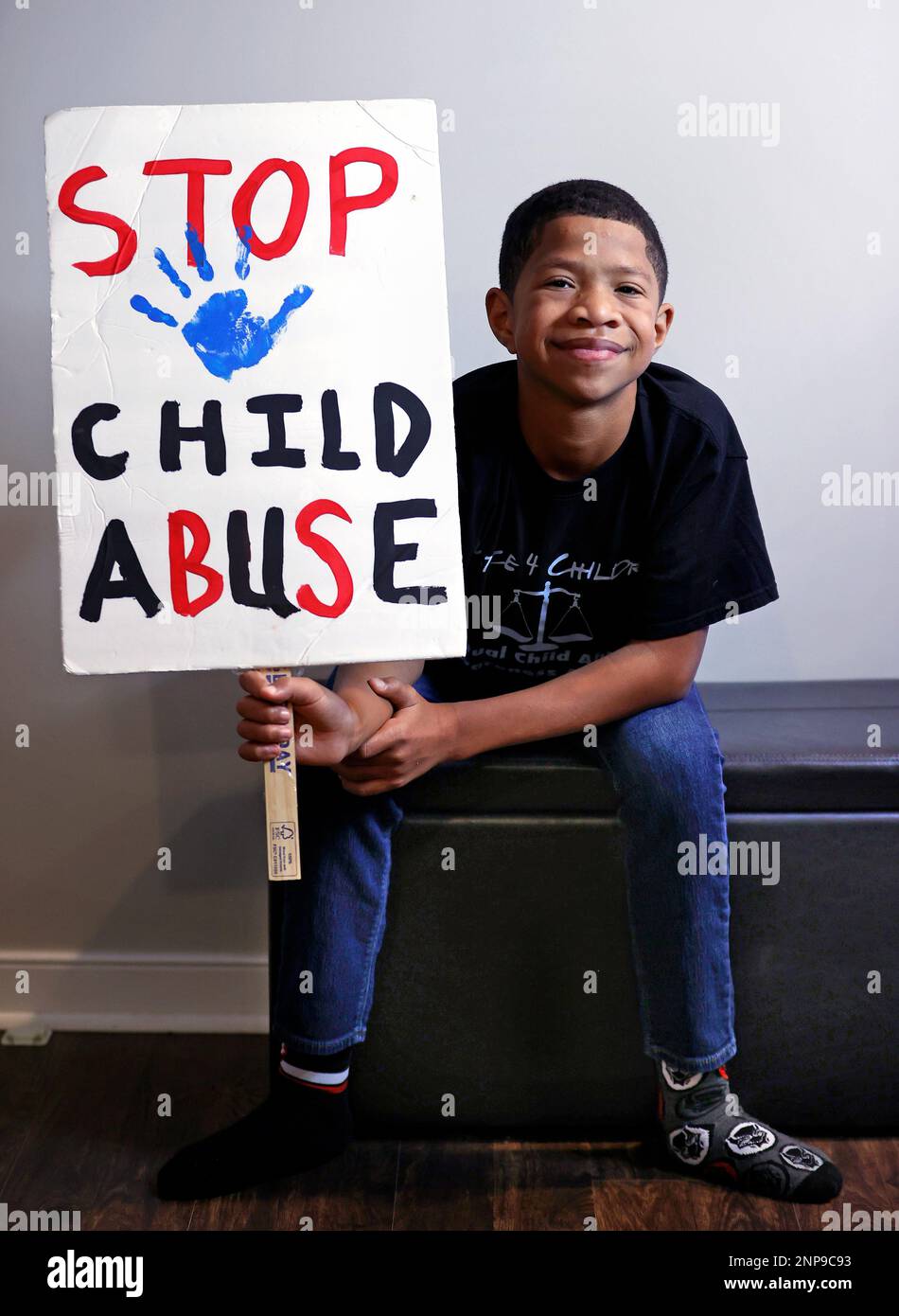 Elijah Lee, 12, holds one of the posters carried during a protest he ...