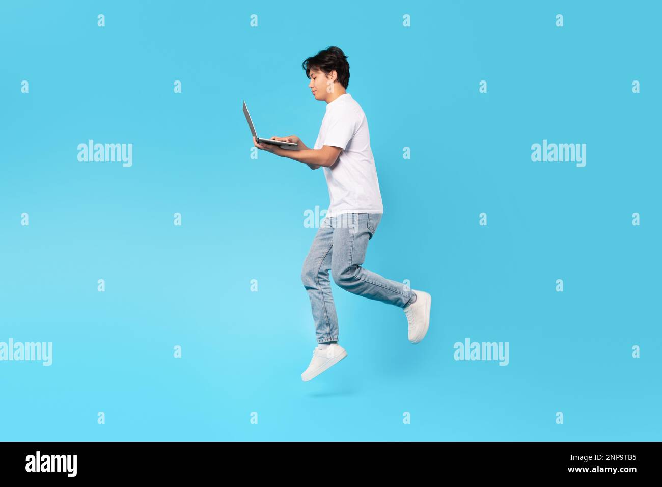 Asian Teen Boy Holding Laptop Jumping Browsing Internet, Blue ...