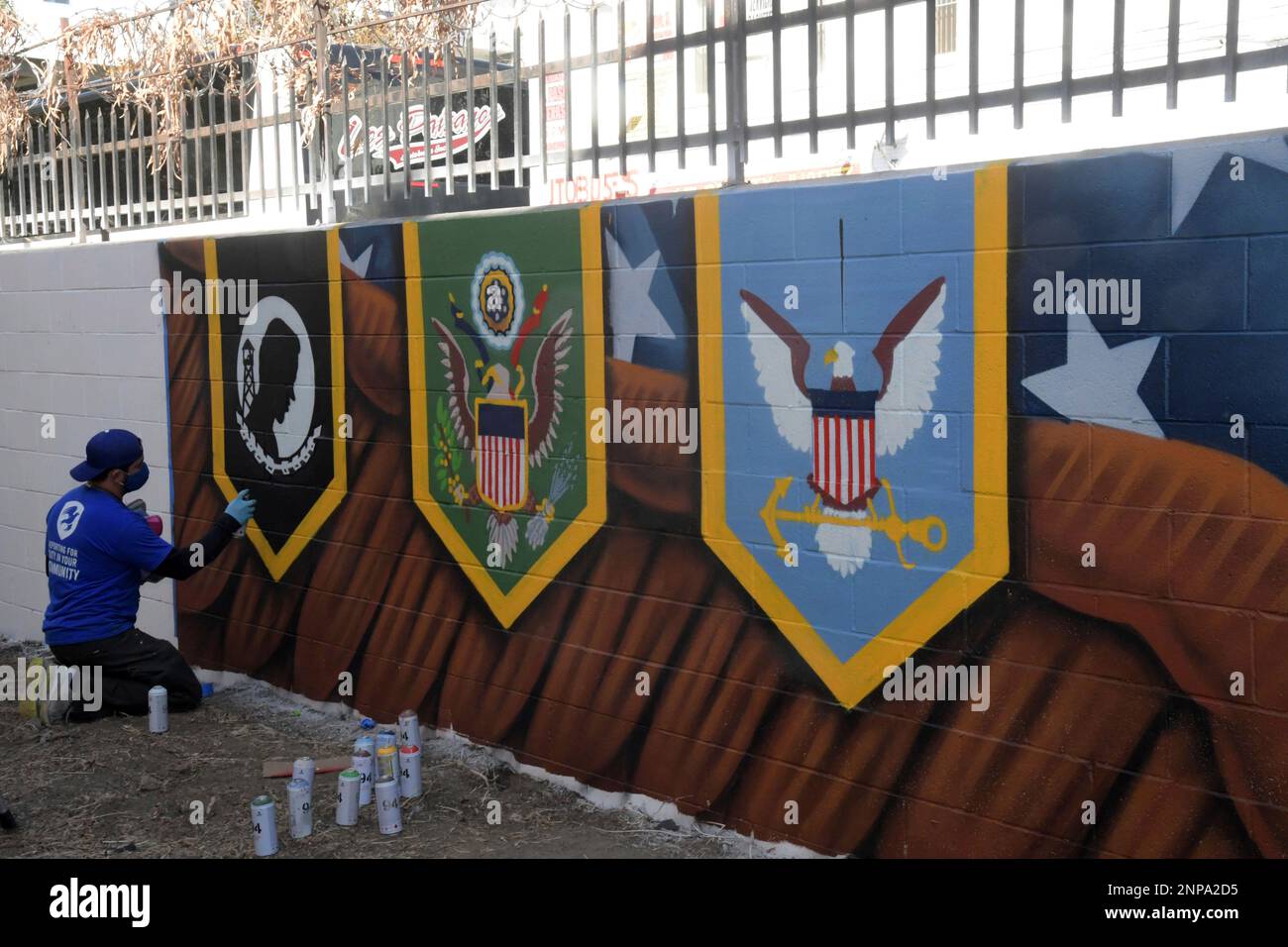 A volunteer paints a mural at the MLB All-Star Veterans Courtyard ...