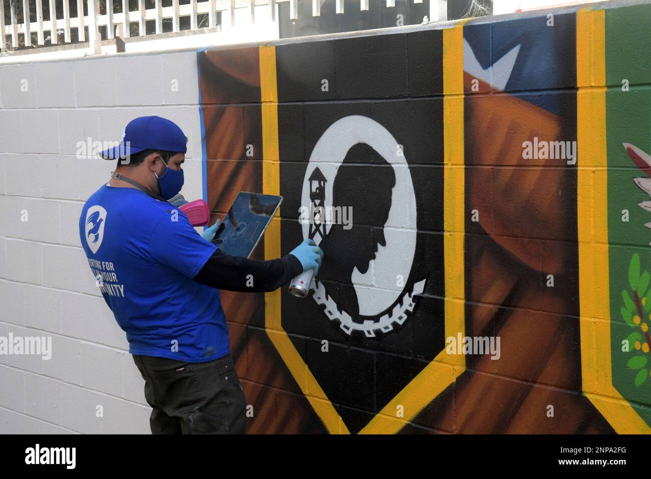 A volunteer paints a mural at the MLB All-Star Veterans Courtyard ...