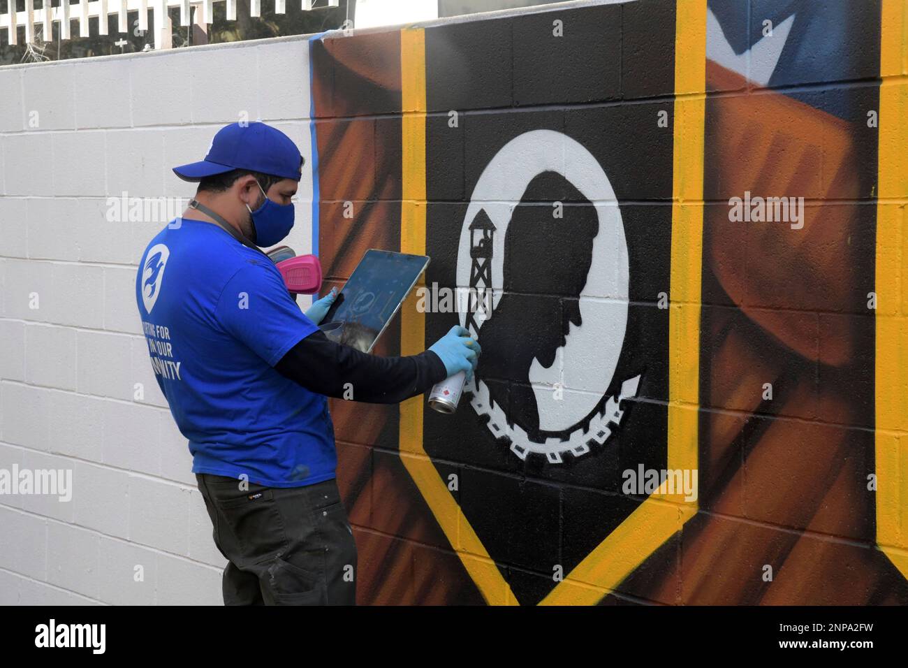 A volunteer paints a mural at the MLB All-Star Veterans Courtyard ...