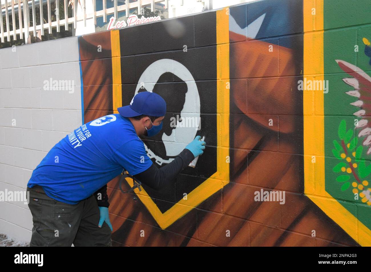A volunteer paints a mural at the MLB All-Star Veterans Courtyard ...