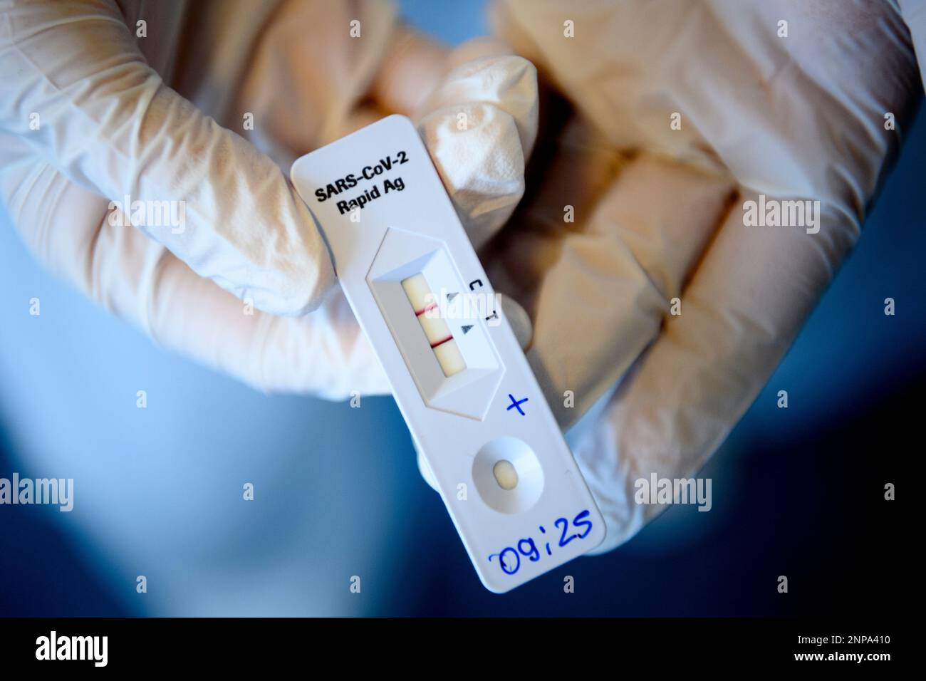 A health worker shows a positive 'SARS-CoV-2 Rapid Antigen' test just ...
