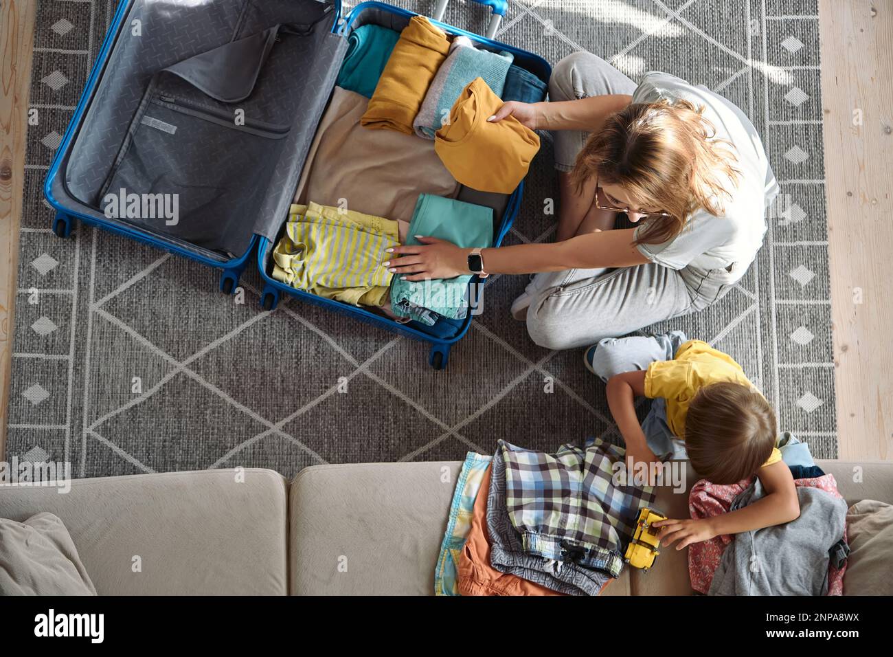 Family going on a trip or vacation, mother packing a suitcase, child ...