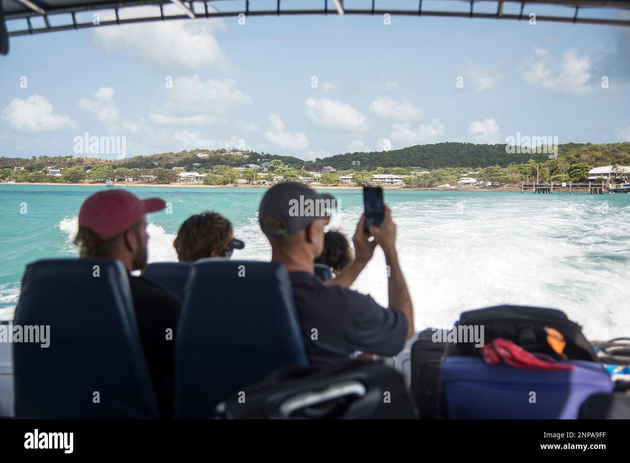 A tourist takes a photo of Thursday Island from a ferry on route to ...