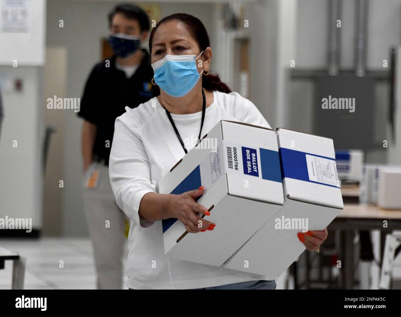 Sylvia Lira carries ballots to be processed during election night, at the Los Angeles County ...