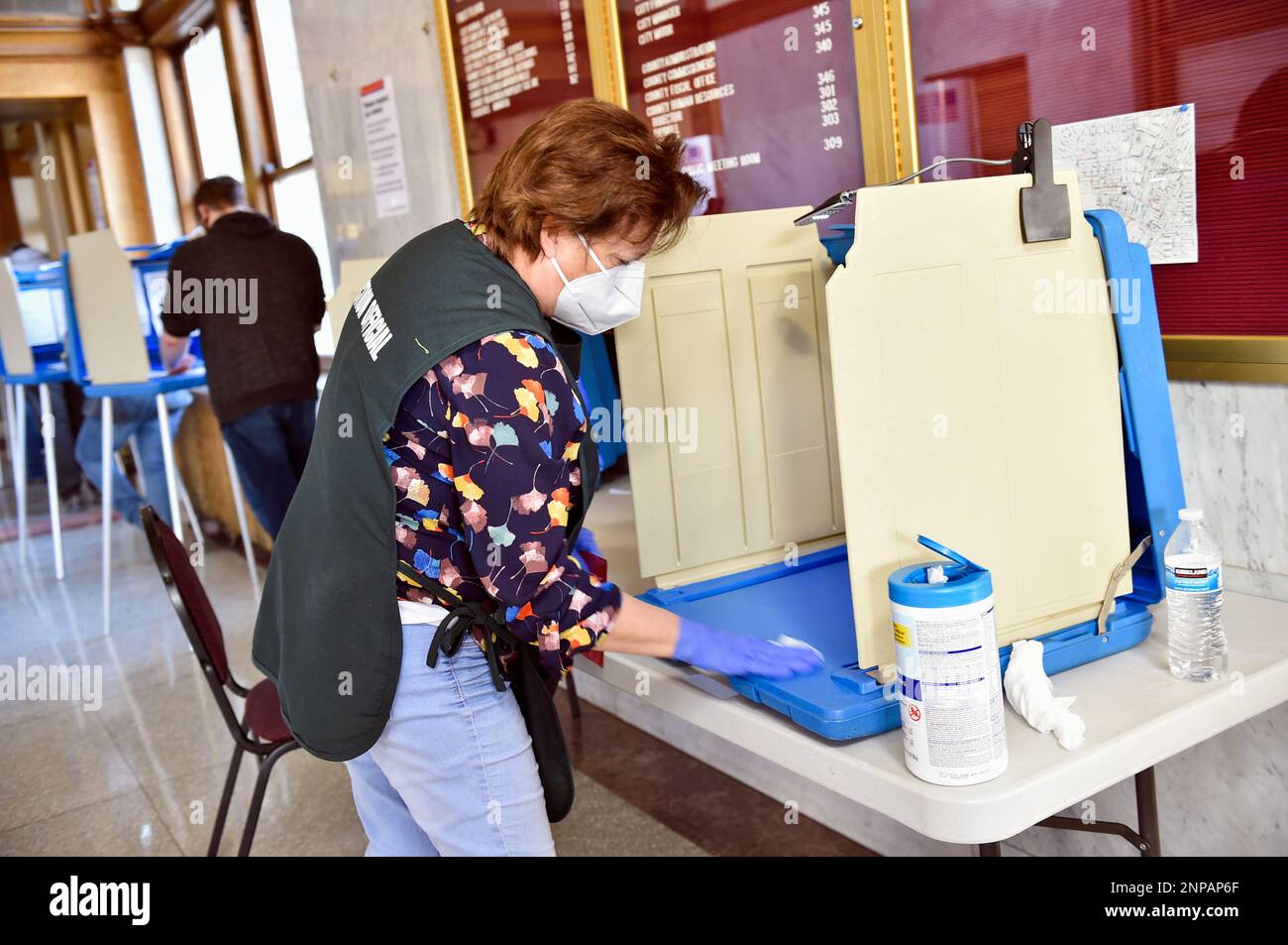 A poll worker sanitizes a voting booth at the Lewis and Clark County ...
