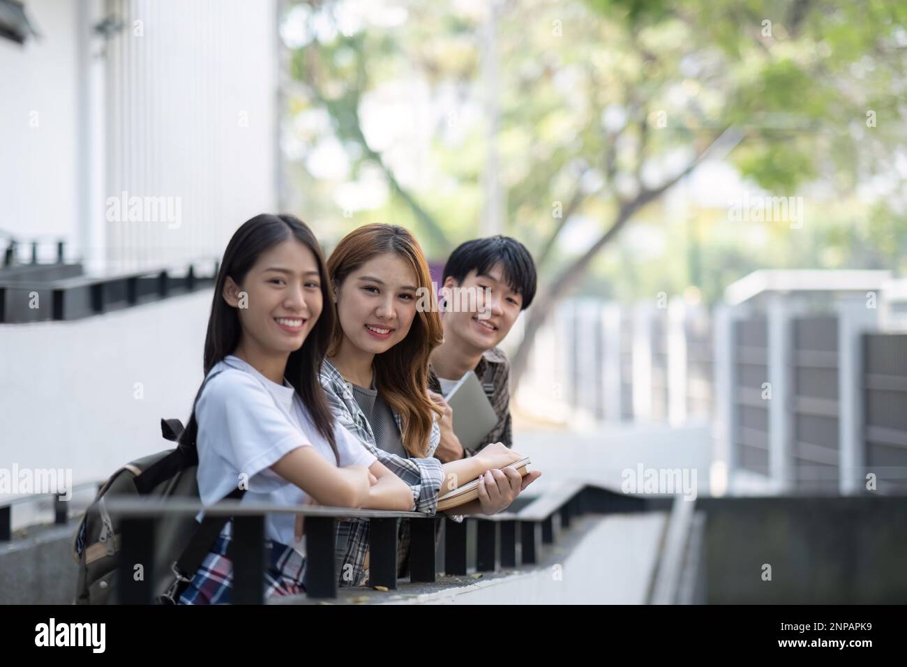Group of young Asian college students sitting on in front of the school ...