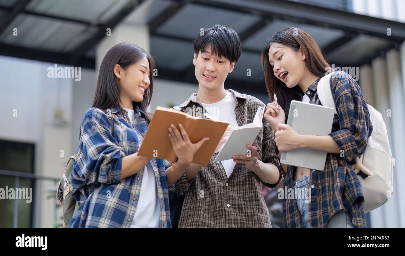 Group of young Asian college students sitting on in front of the school ...