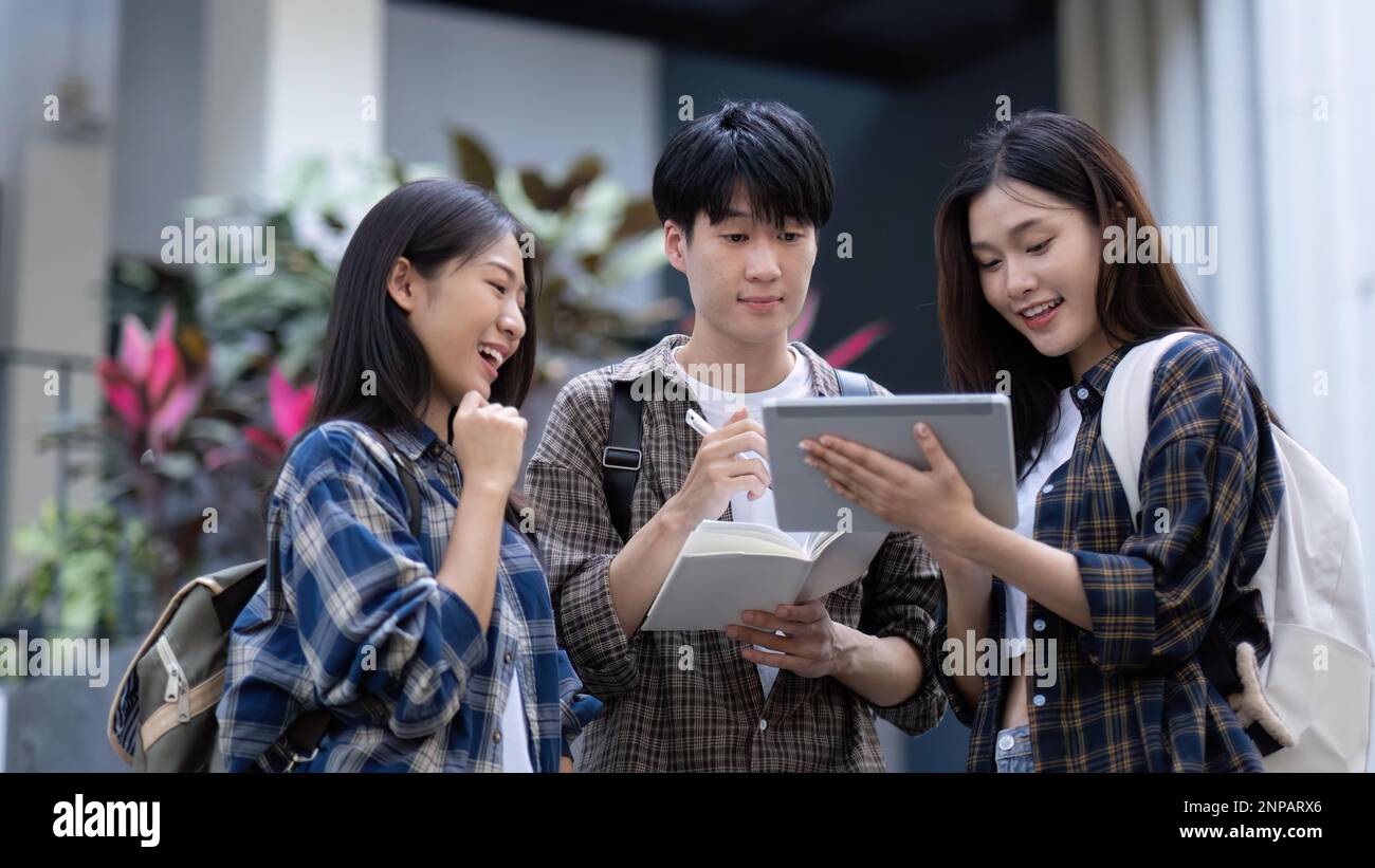 Group of young Asian college students sitting on in front of the school ...