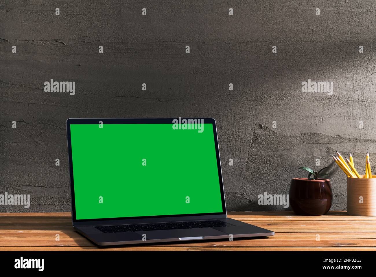 Chroma key green screen, angled view laptop on wooden table in front of ...