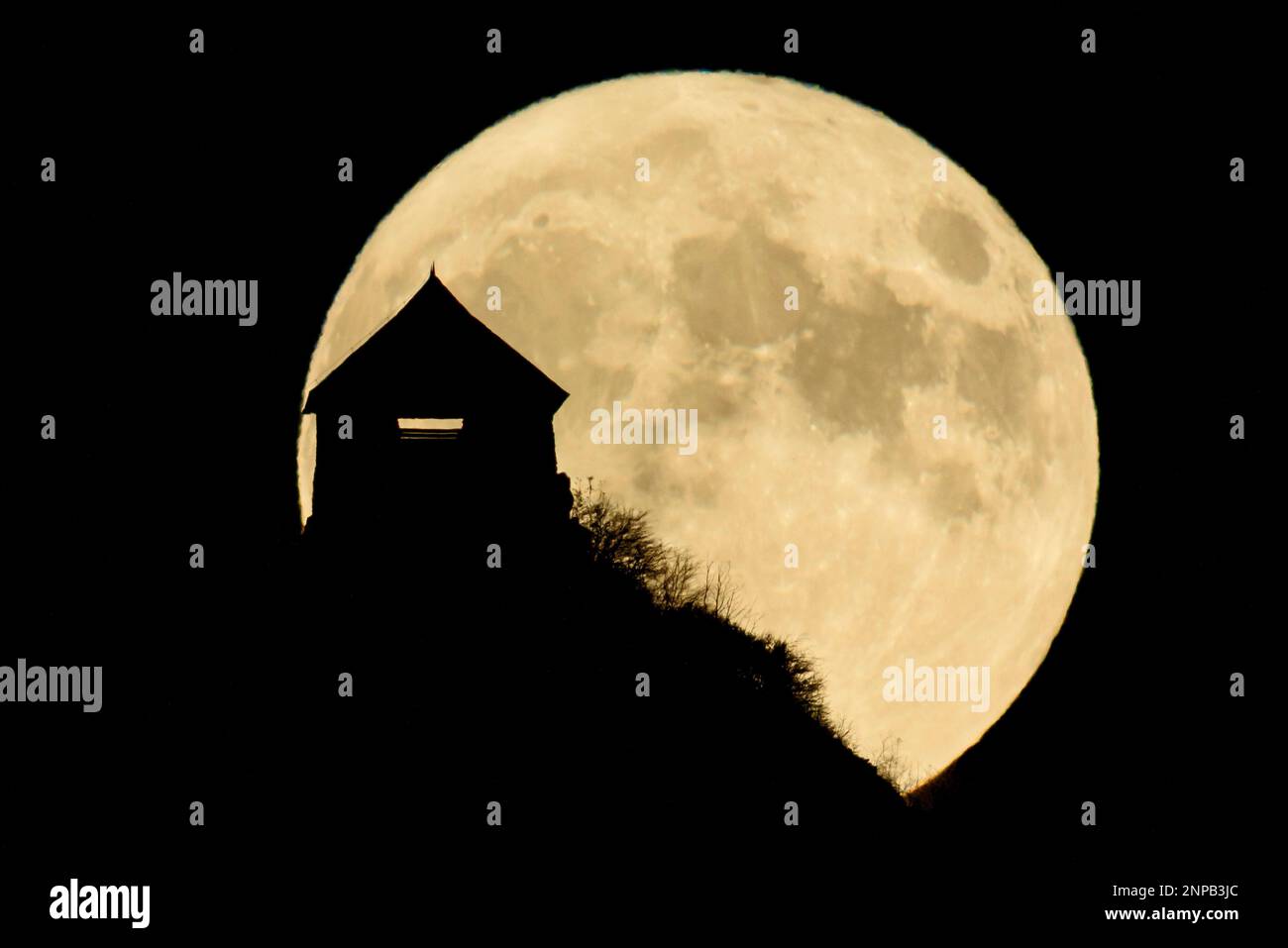The full moon rises above the Salgo Castle pictured from Salgotarjan ...