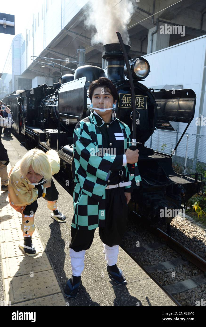 Kimetsu no Yaiba costume-clad fans pose with a steam locomotive (SL ...