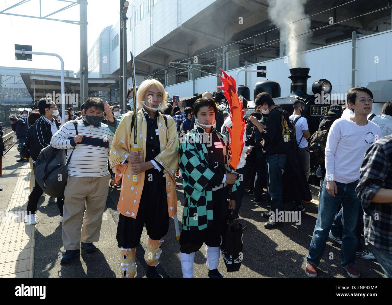 Kimetsu no Yaiba costume-clad fans pose with a steam locomotive (SL ...