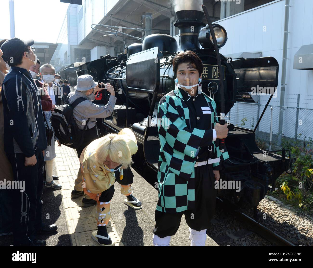 Kimetsu no Yaiba costume-clad fans pose with a steam locomotive (SL ...